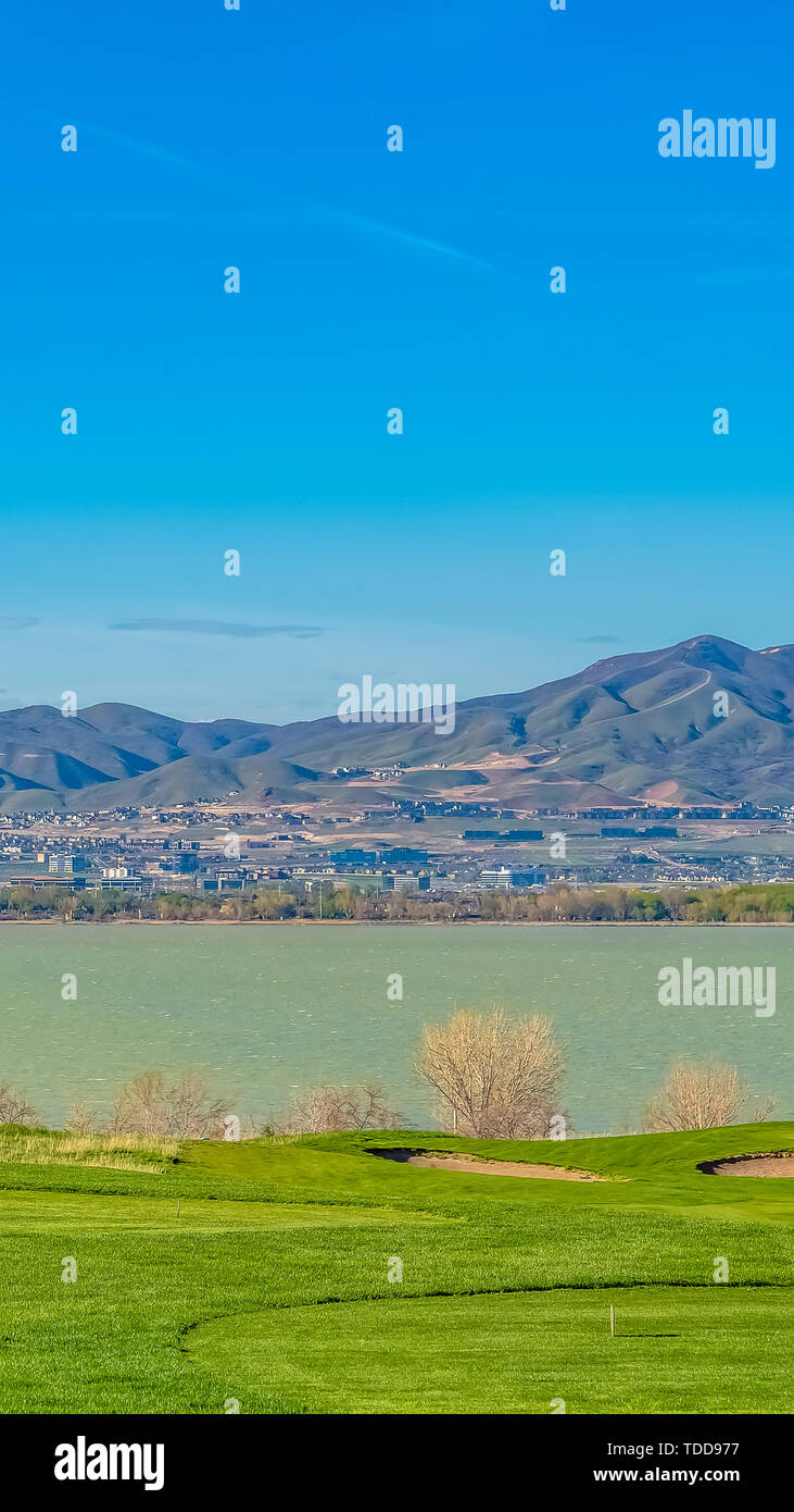 Vertical frame Mountain towering over a vast valley and lake under ...
