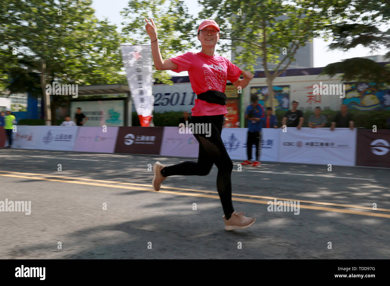 An athlete joyfully runs to the finish line in a women's marathon Stock ...