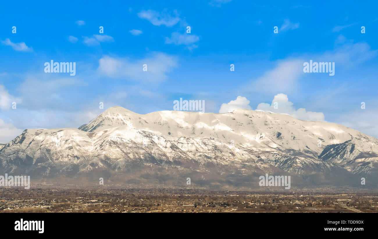 Panorama Houses and buildings on a vast valley under bright blue sky ...