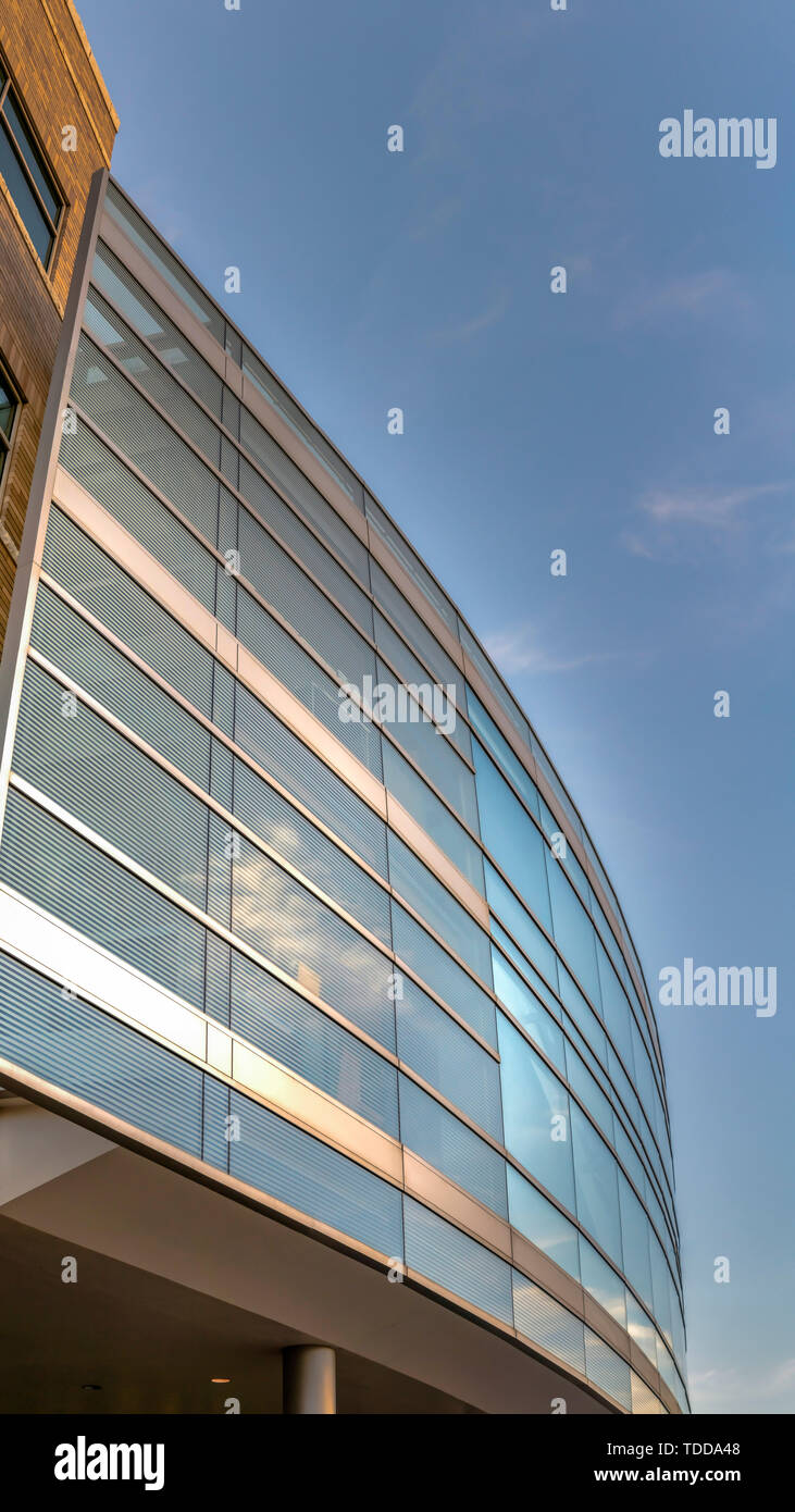 Vertical Exterior of a modern building seen from below with blue sky ...