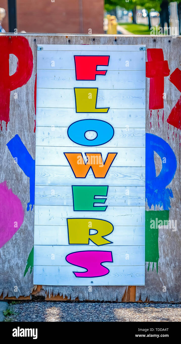 Vertical Flowers sign with a colorful font attached to a weathered ...