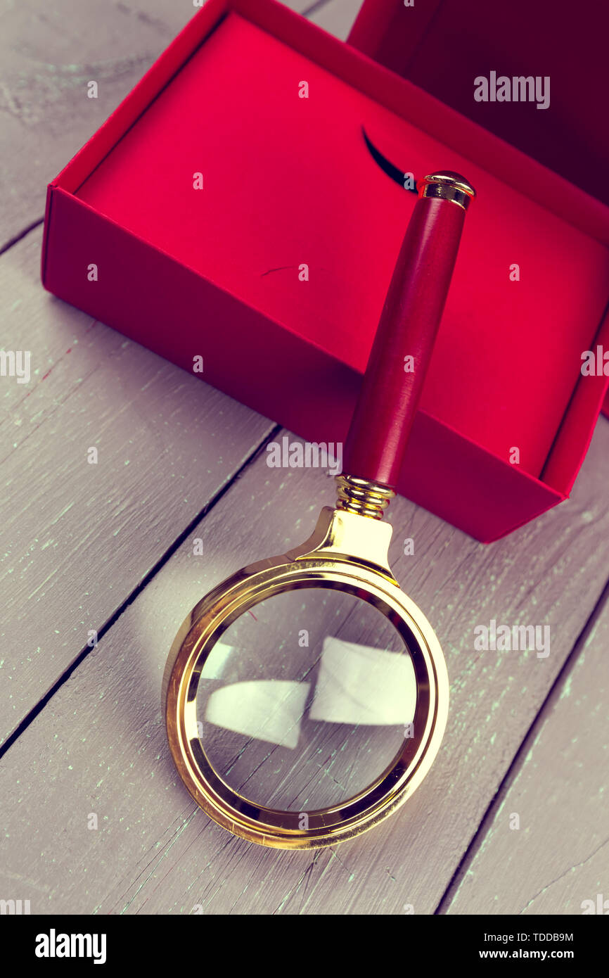 Gift box with magnifying glass Stock Photo - Alamy