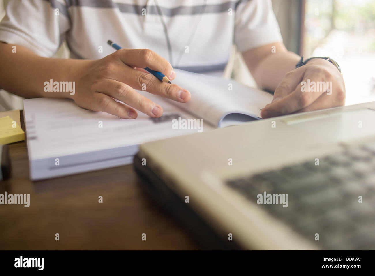 Closeup of student hand using pen while studying on workbook Stock ...