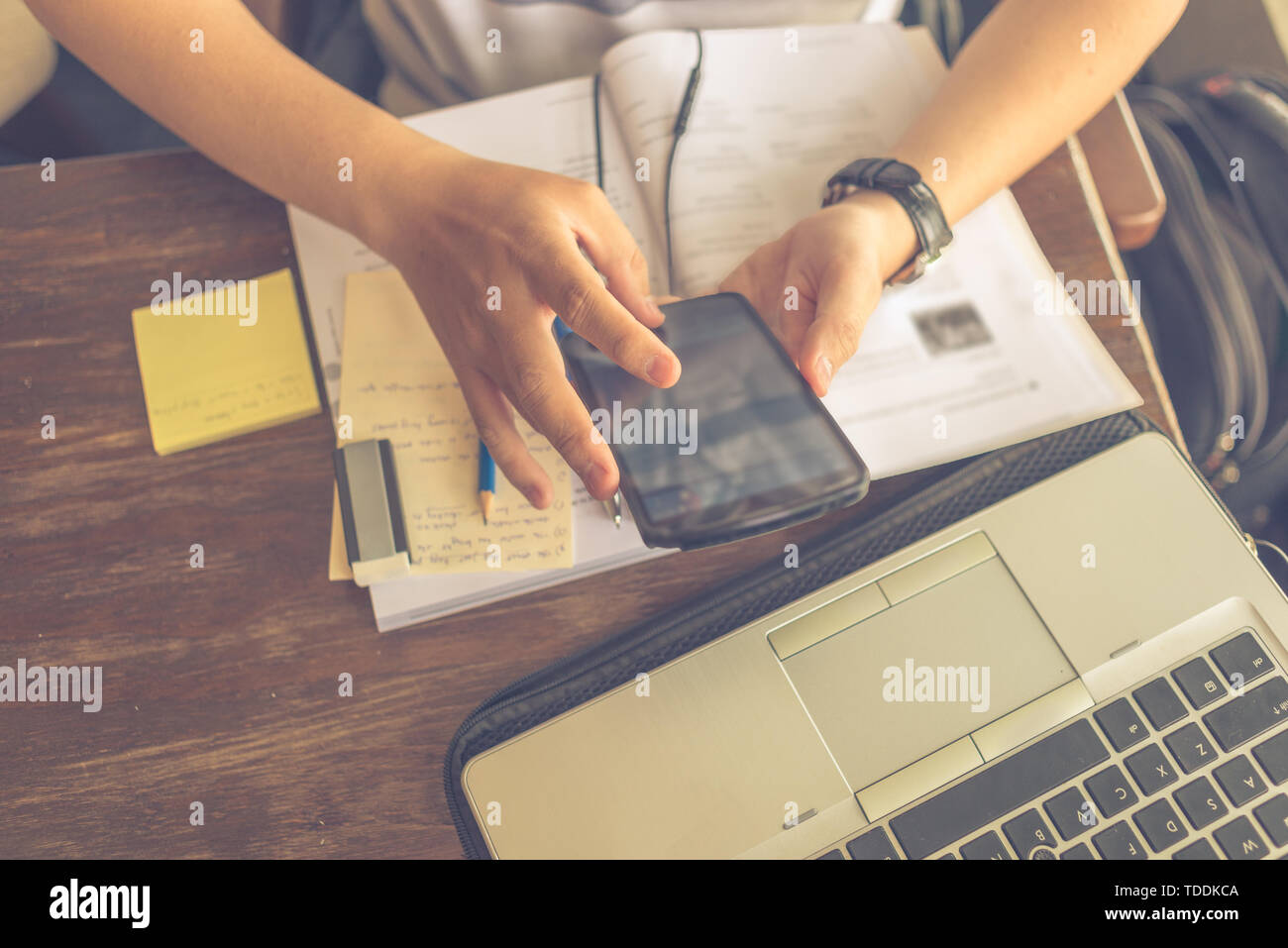 Closeup of student hands using cellphone while studying Stock Photo - Alamy