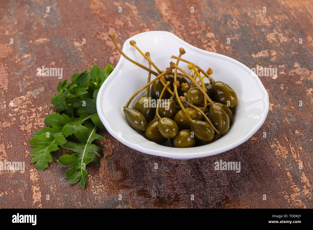 Pickled Capersberries in the bowl with basil Stock Photo - Alamy
