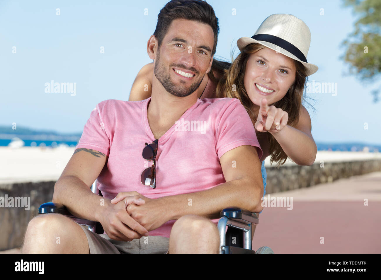 man in wheelchair woman pointing into distance Stock Photo - Alamy