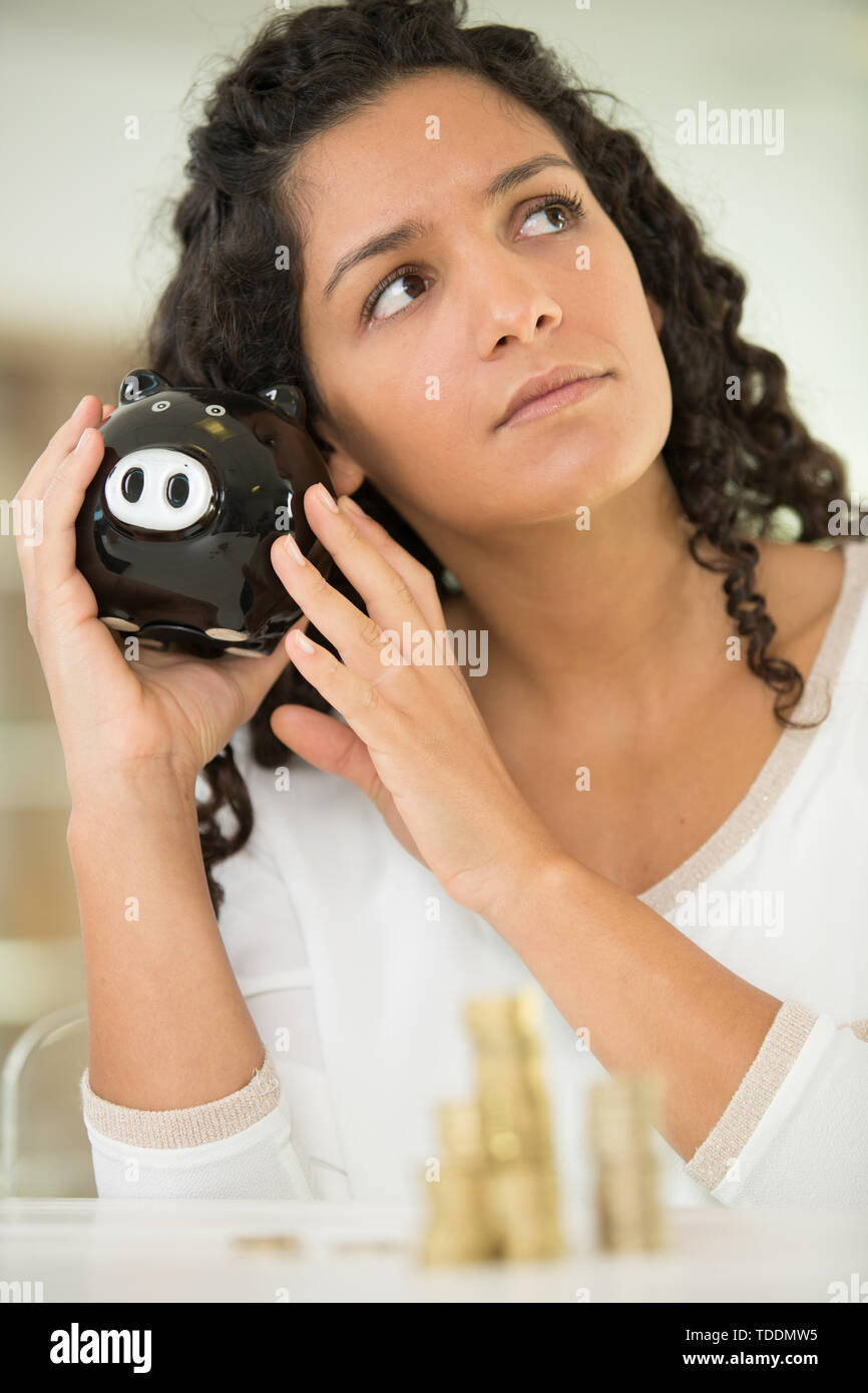 sad woman shaking a piggy bank at home Stock Photo - Alamy