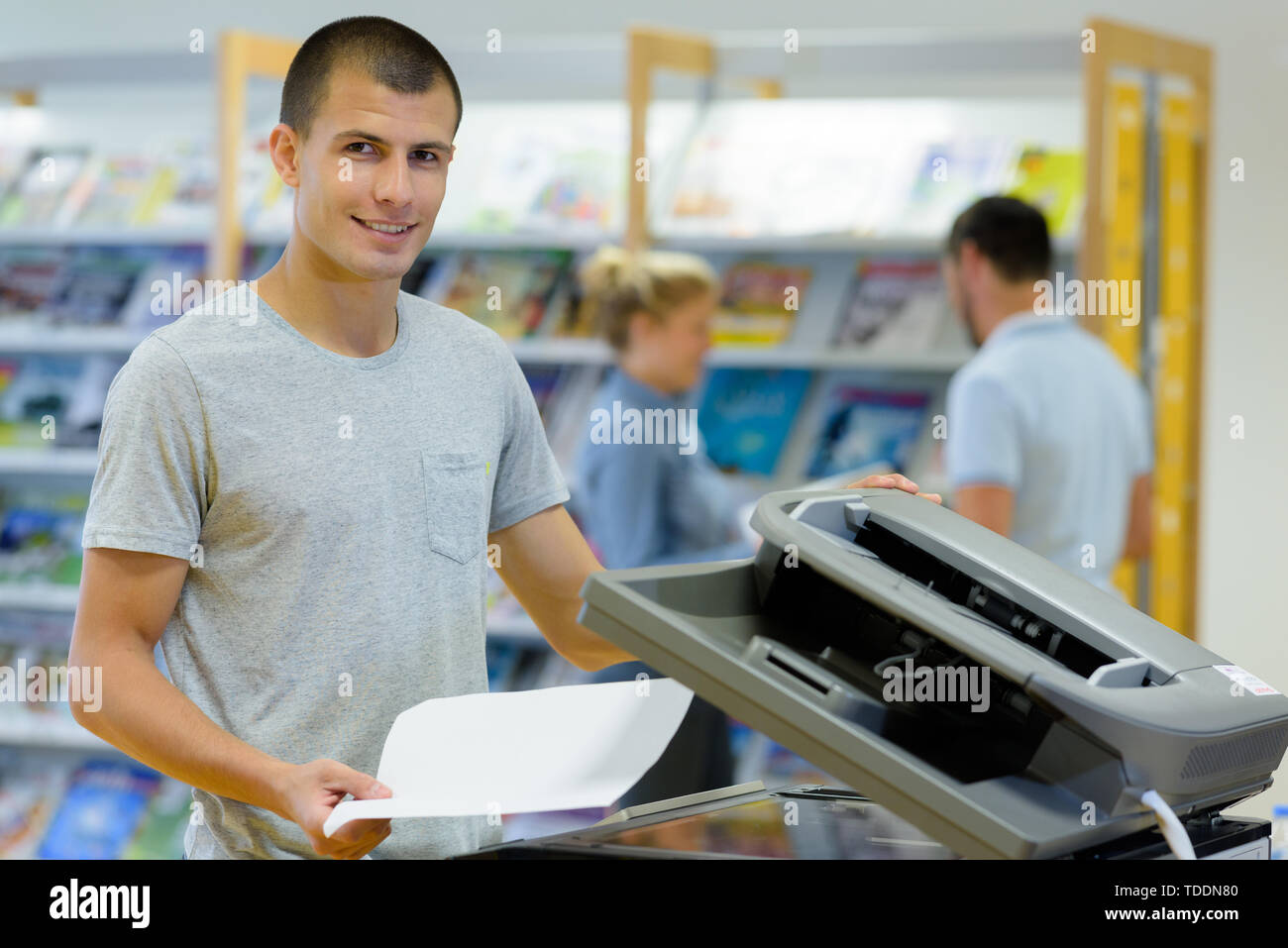 young man posing while using photocopier machine Stock Photo - Alamy