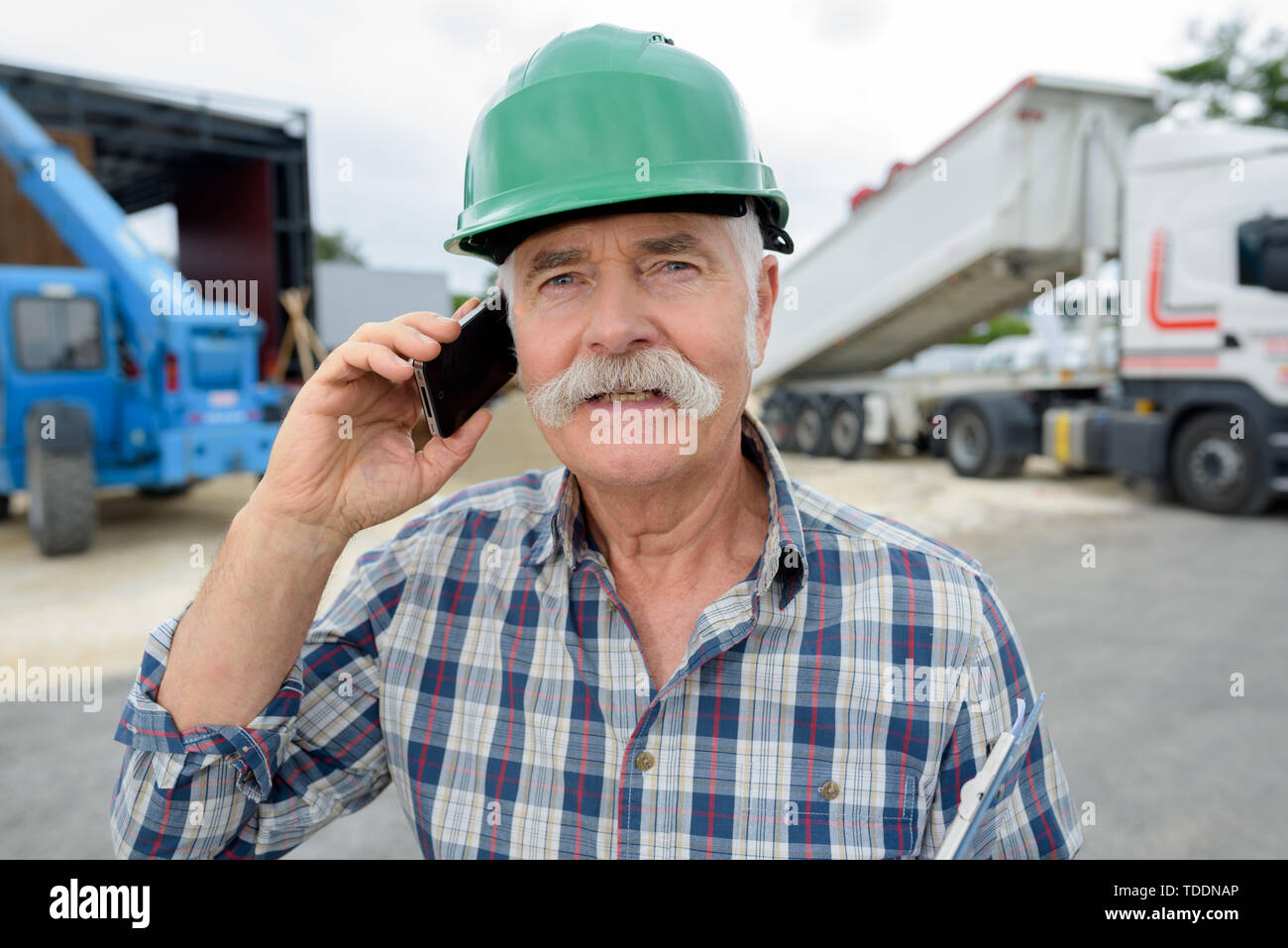 senior manual worker calling on the phone Stock Photo - Alamy