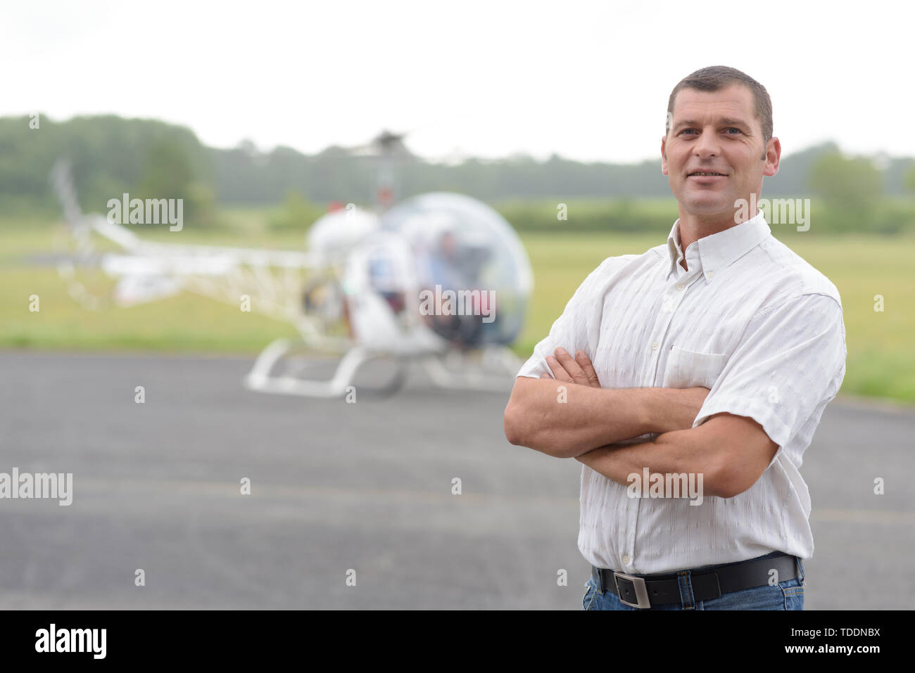 portrait of man at airfield helicopter in background Stock Photo - Alamy