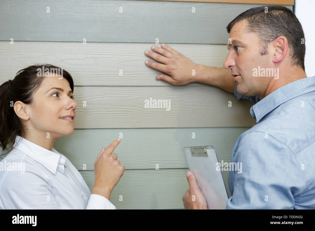 young smiling people choosing wood panelling Stock Photo - Alamy