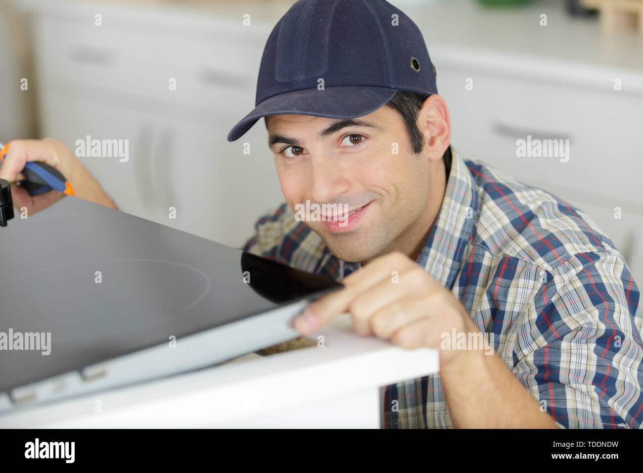 workman installing luxury fitted kitchen Stock Photo - Alamy
