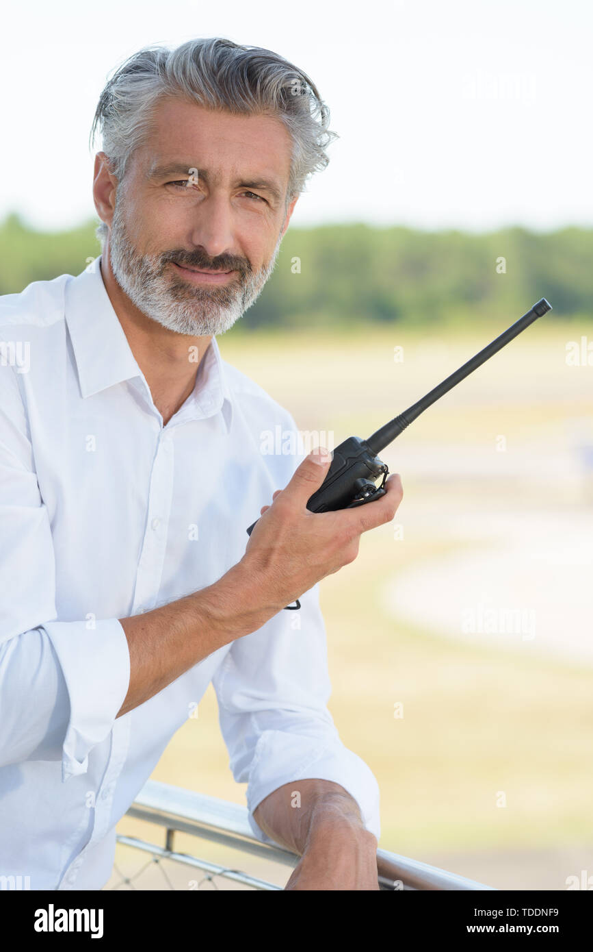 man in casual attire holding walkie talkie Stock Photo - Alamy