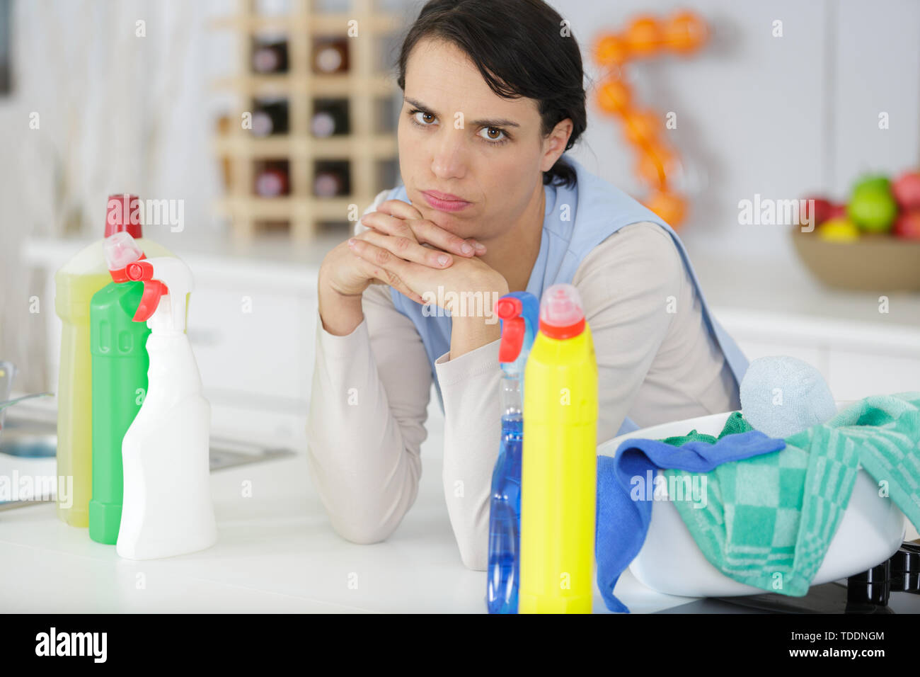 upset woman with cleaning products Stock Photo - Alamy
