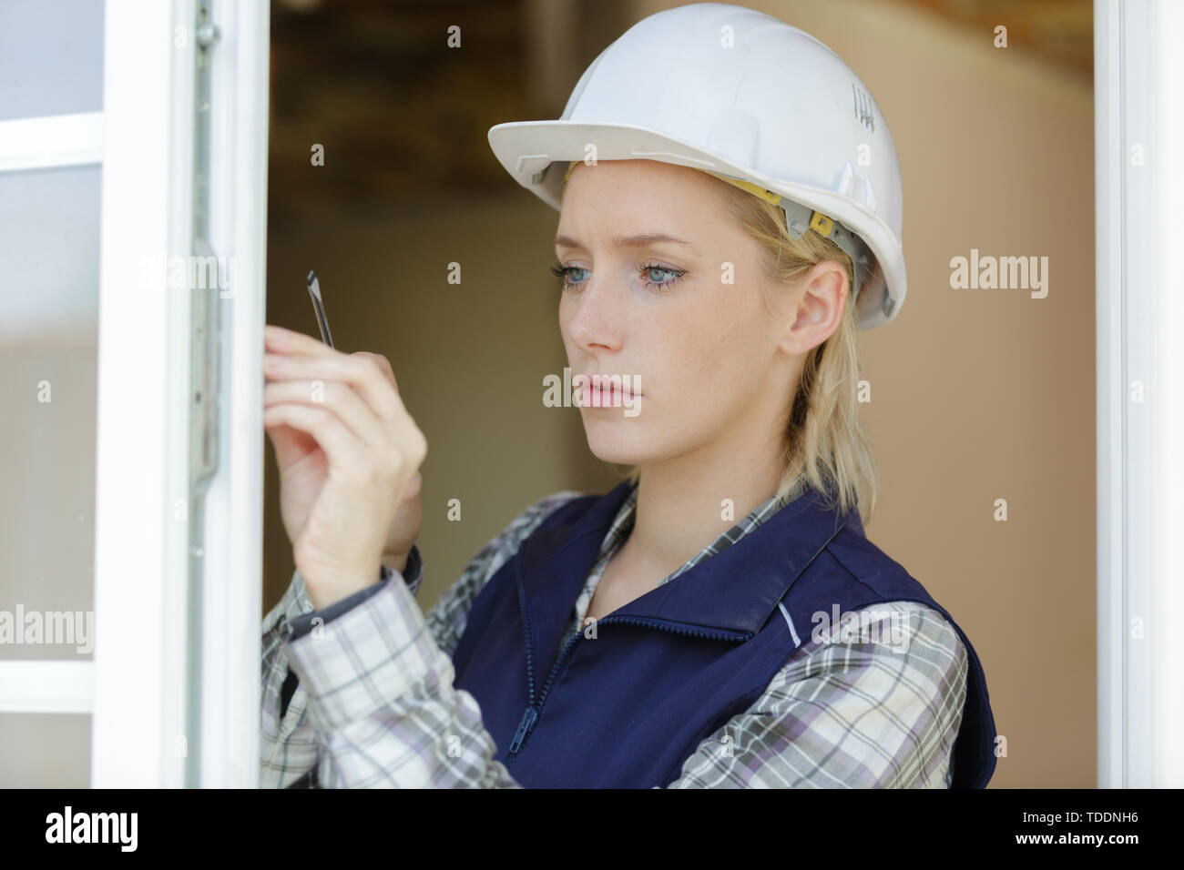 woman builder fixing a window Stock Photo - Alamy