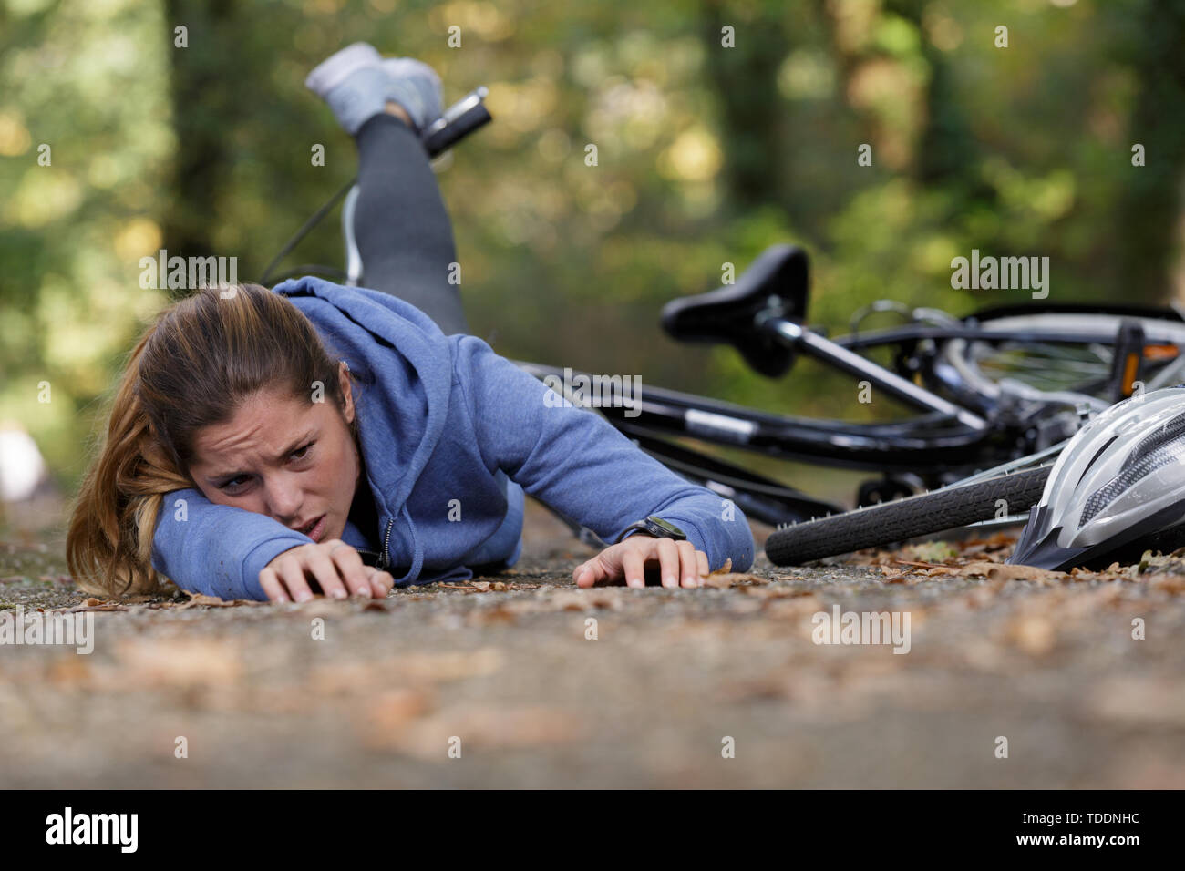 female biker fell off her bike Stock Photo - Alamy