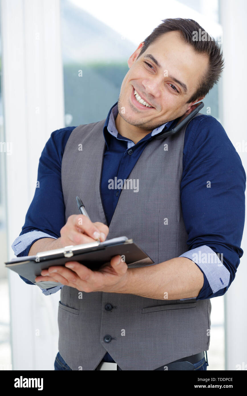 successful man with clipboard smiling into camera Stock Photo - Alamy