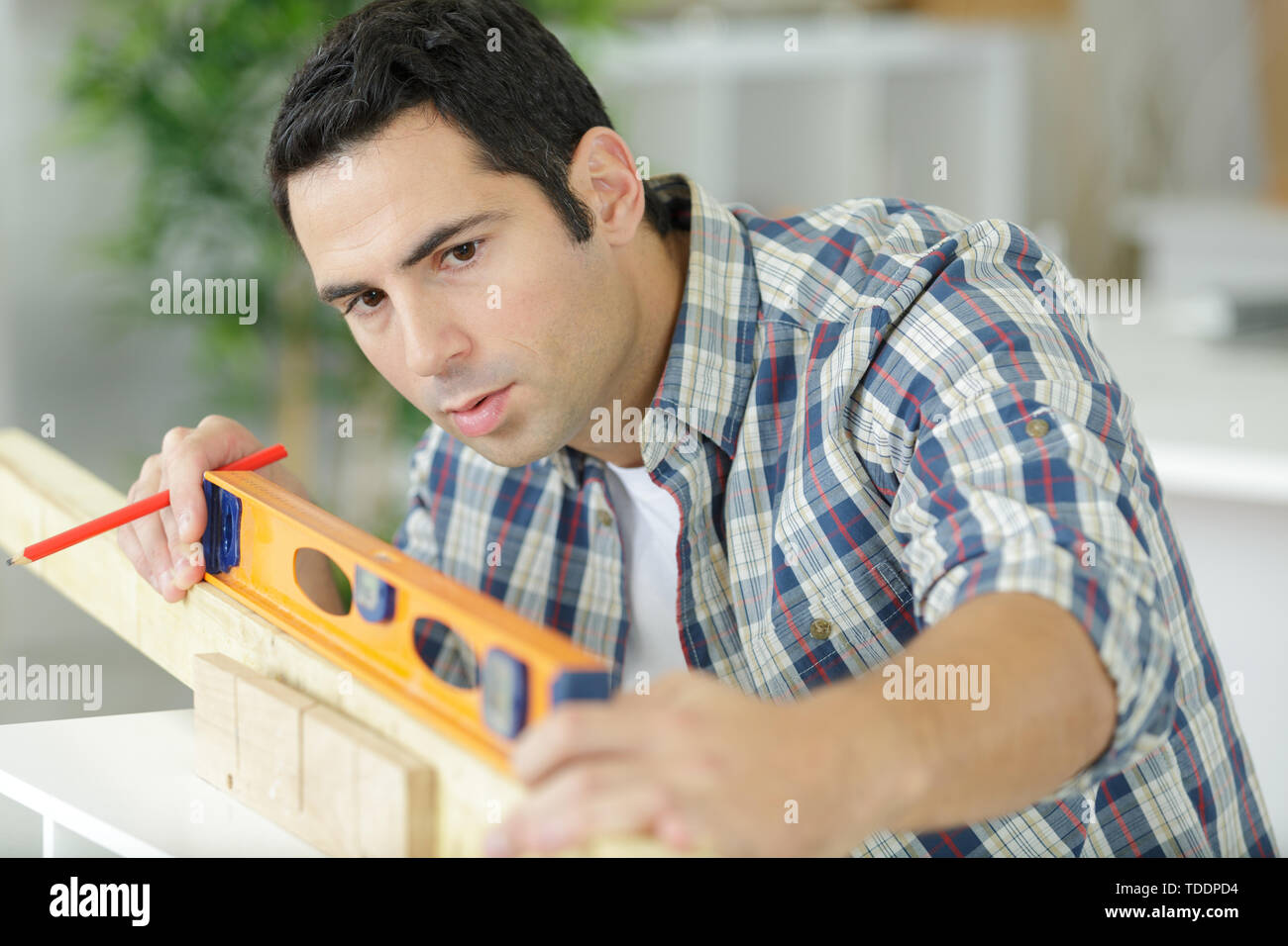 craftsman using spirit level on length of wood Stock Photo - Alamy