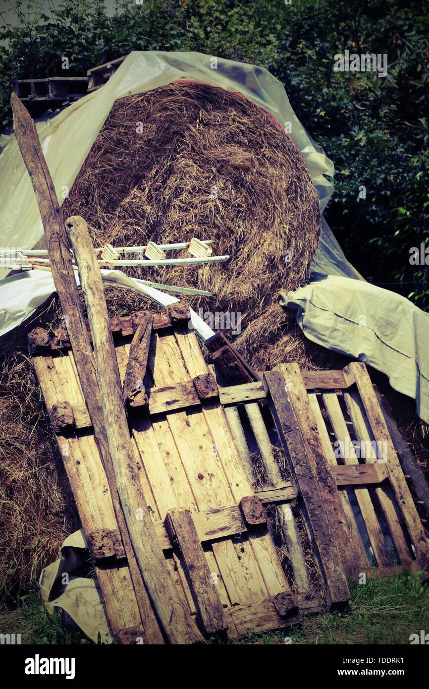 big haystack with wooden pallets in the farm with old toned effect ...