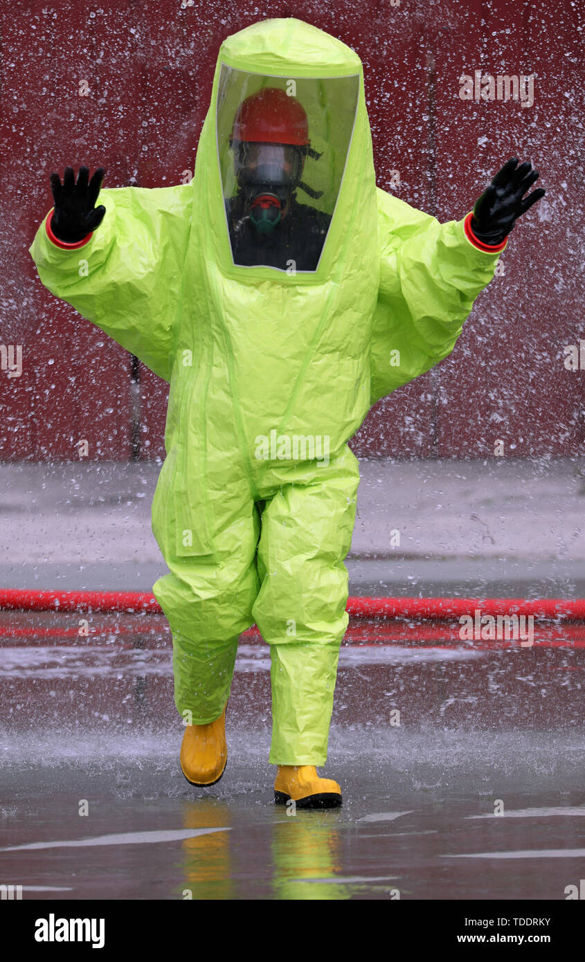 fireman with yellow protective suit and spray water Stock Photo - Alamy