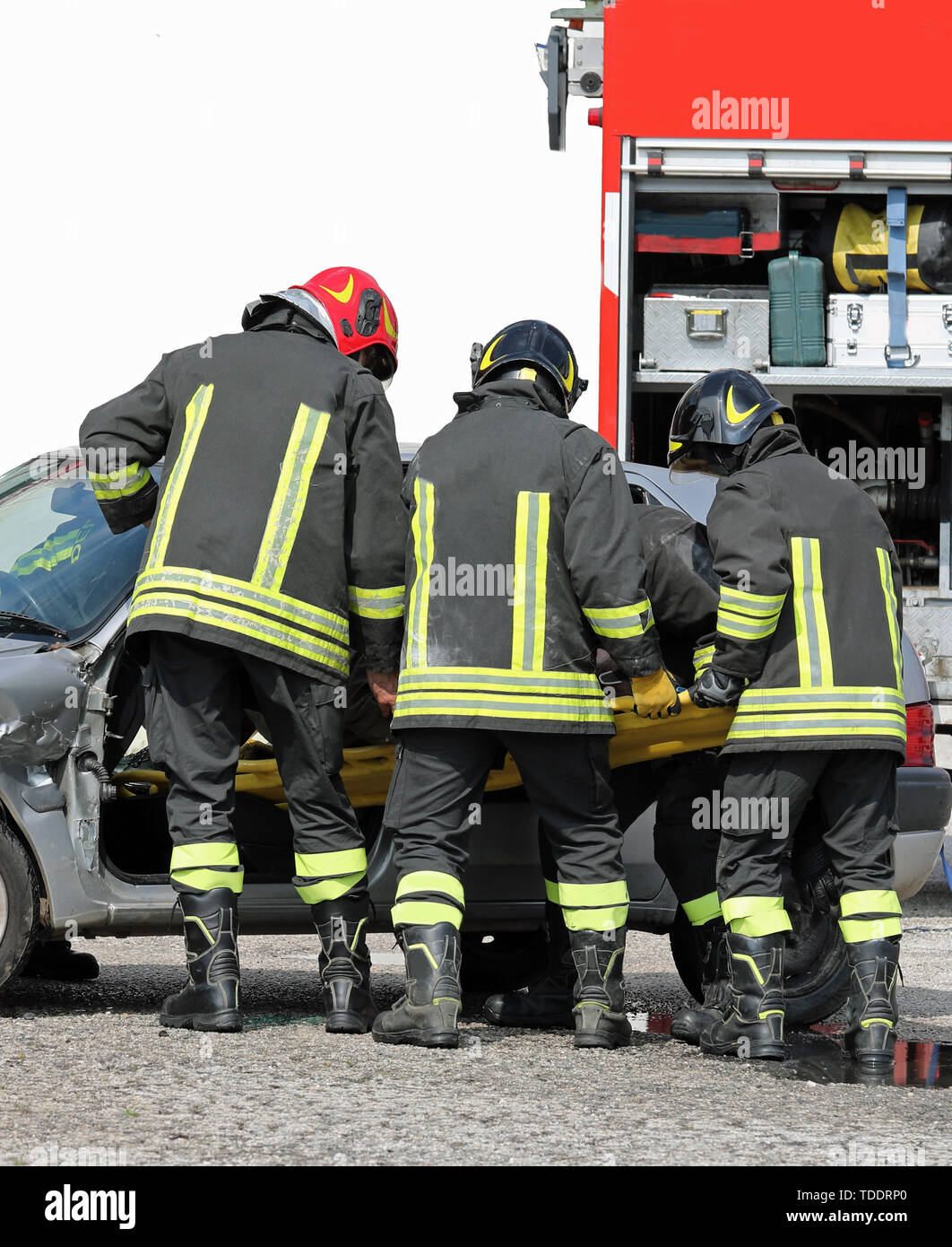 team of firefighters in action after the road accident Stock Photo - Alamy