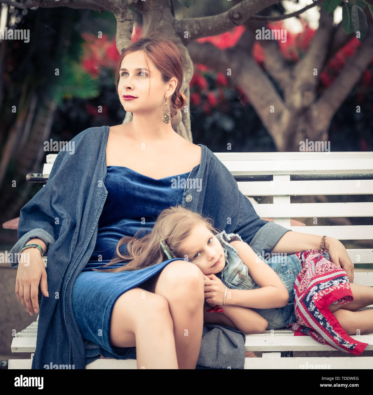 Mother and daughter sitting on a bench in a park Stock Photo - Alamy