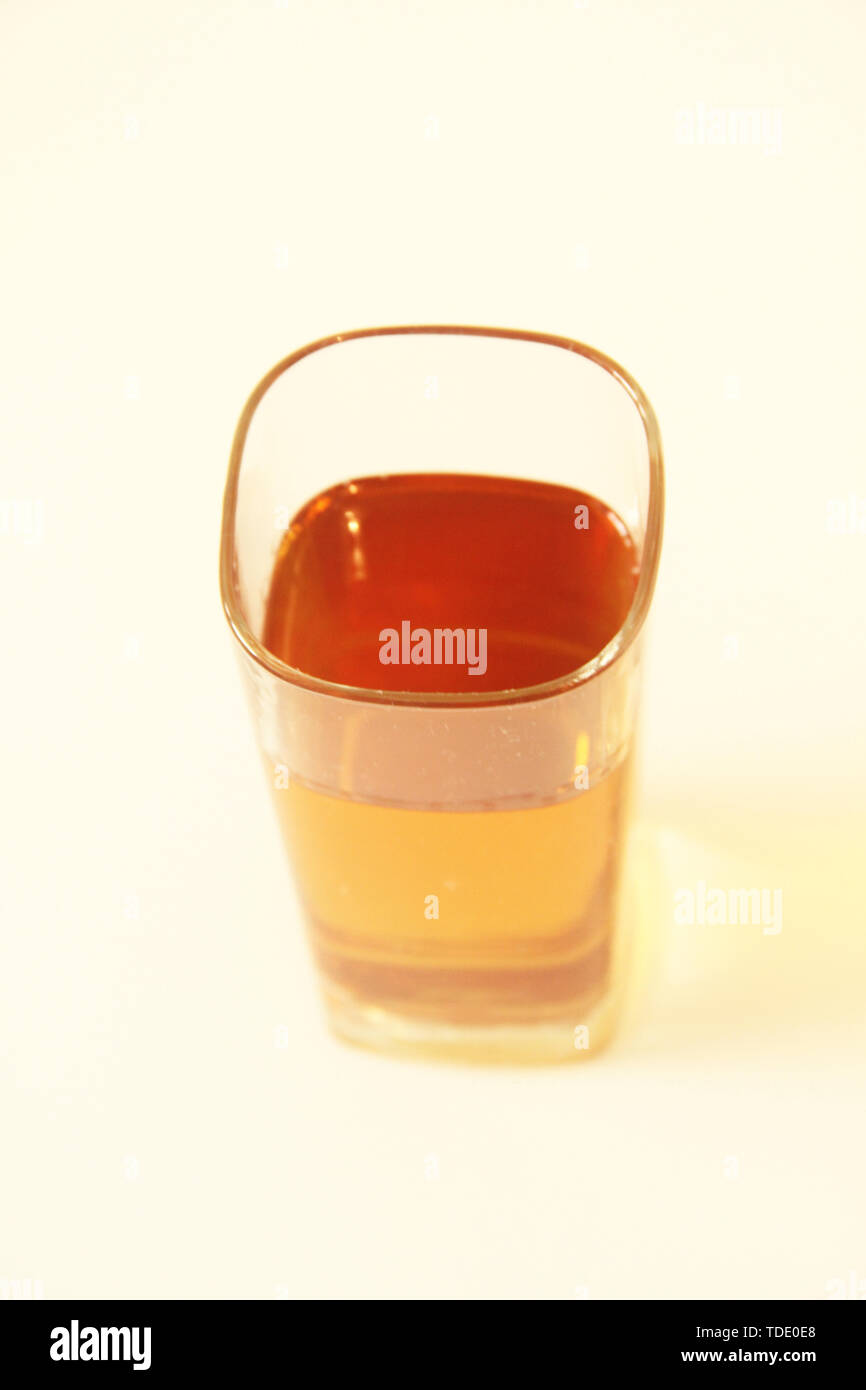 One glass of yellow and transparent liquid on white background, São ...
