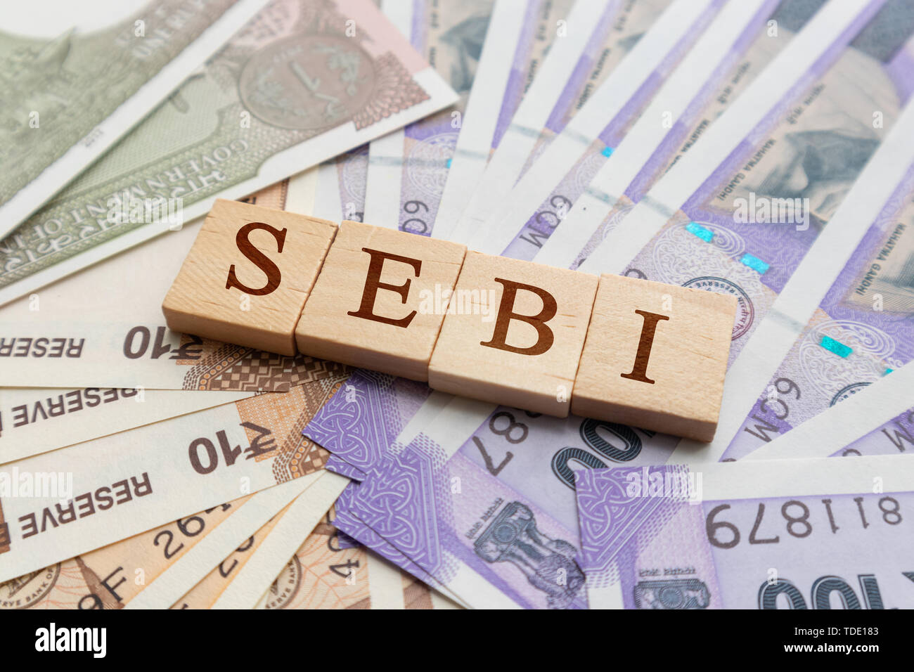 SEBI in wooden block letters on Indian Currency Stock Photo - Alamy