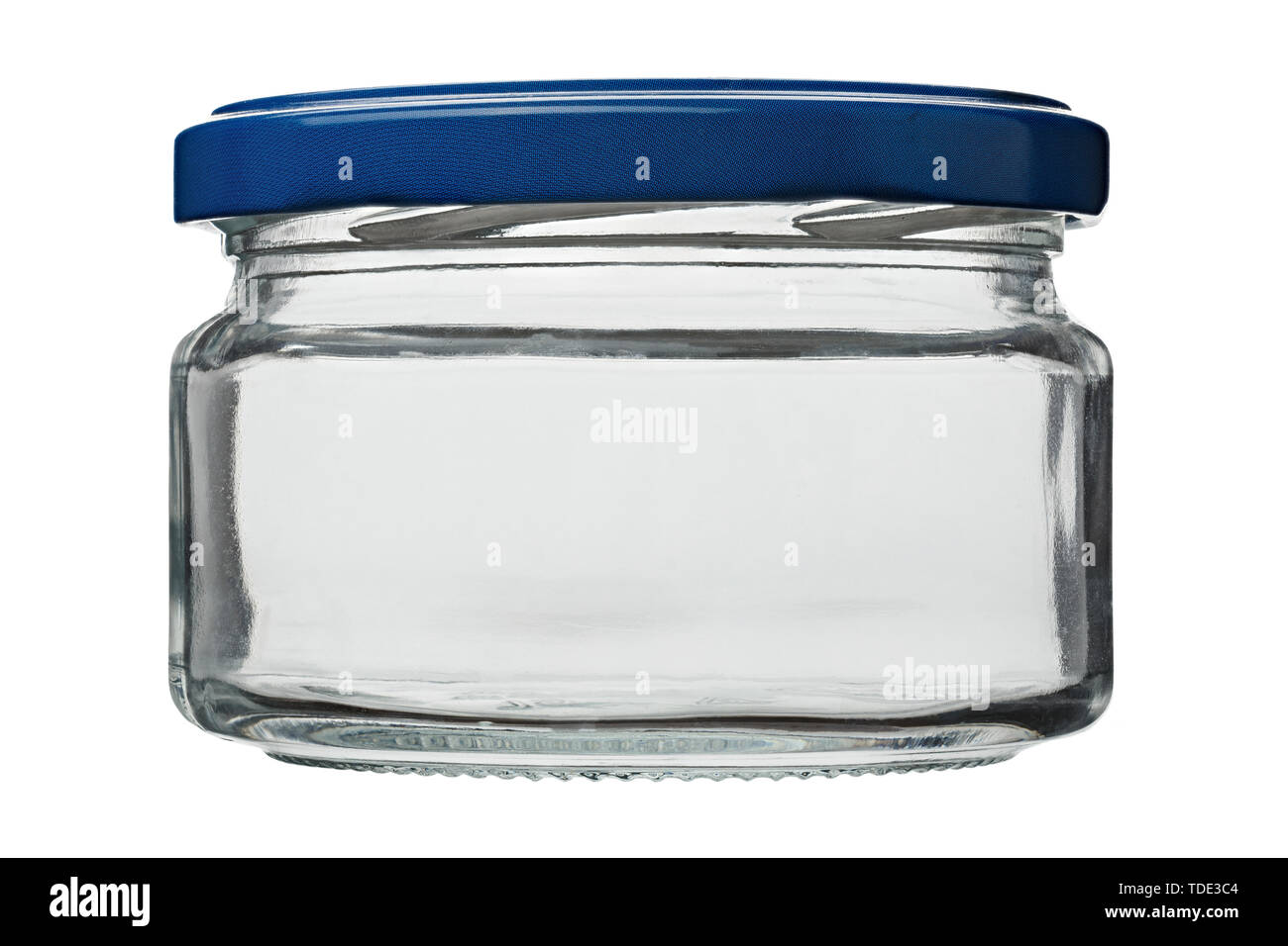 The empty glass jar closed by a metal cover on a white background. File ...