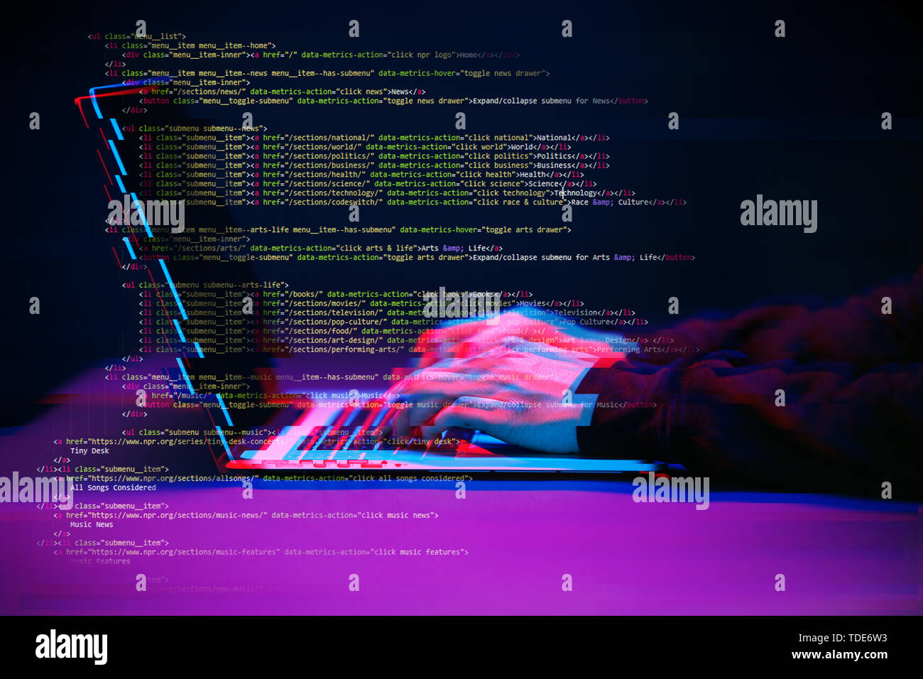 Hacker working with laptop in dark room with digital interface around ...