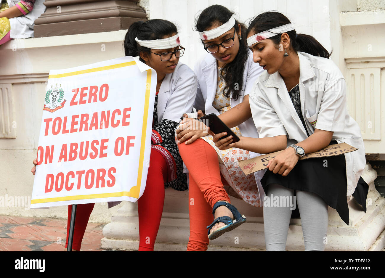 A student holds a placard saying "Zero Tolerance on Abuse of Doctors ...