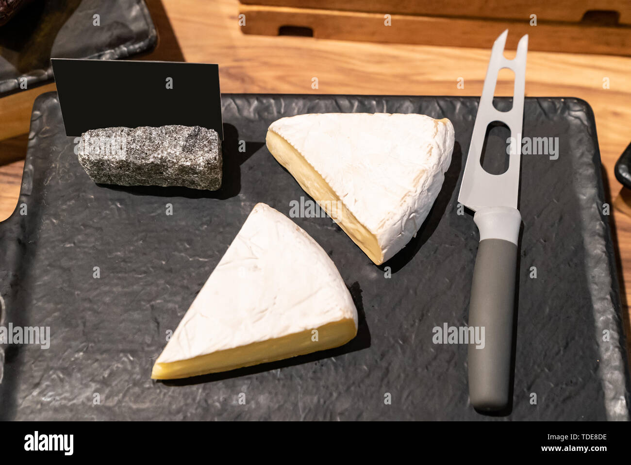 brie cheese on black stone plate in buffet line Stock Photo - Alamy