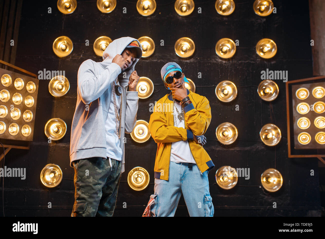 Two black rappers in caps on stage with spotlights Stock Photo - Alamy