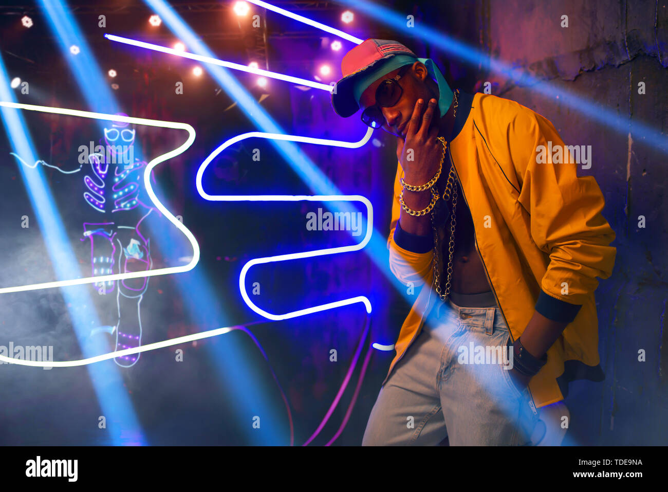 Black rapper in underpass neon light on background Stock Photo - Alamy