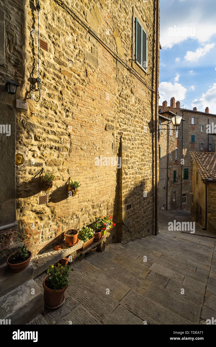A typical narrow street in Cortona historic center. Cortona is a ...