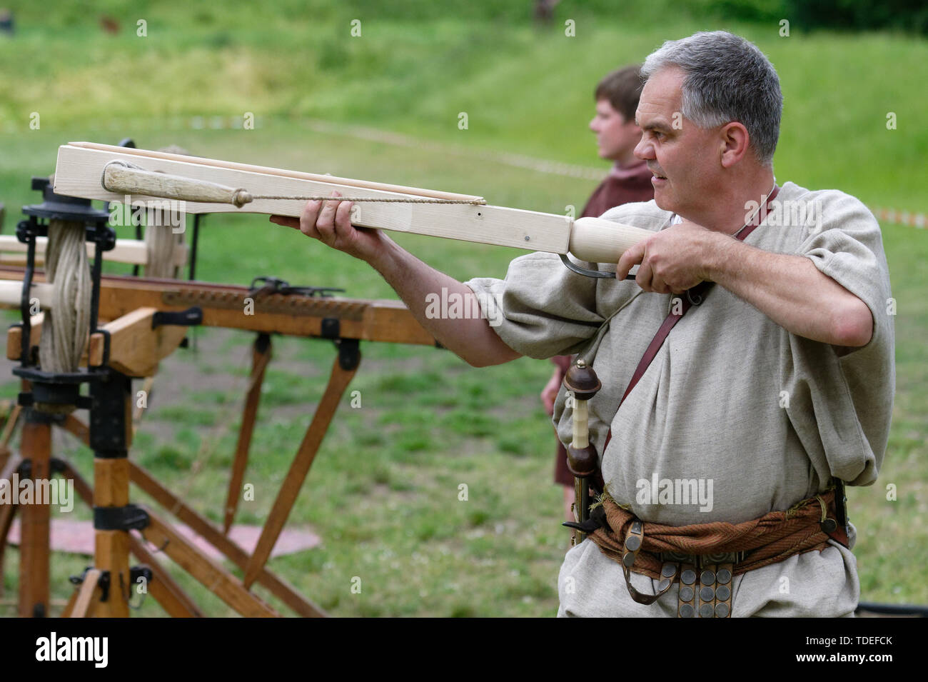Cologne, Germany. 15th June, 2019. Alexander Zimmermann shoots a Roman crossbow on a meadow in ...
