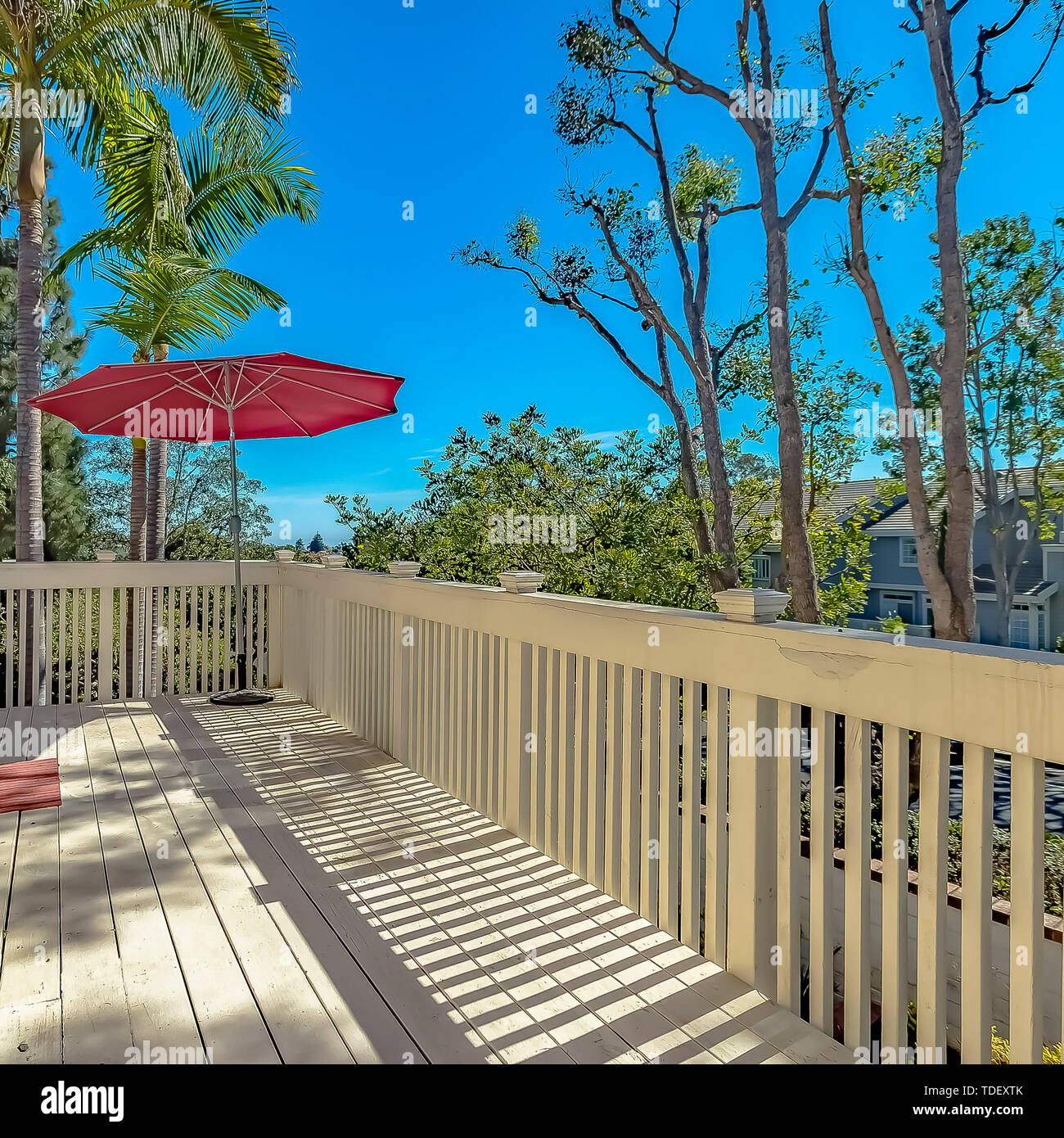 Square Balcony overlooking houses and trees against bright blue sky on ...