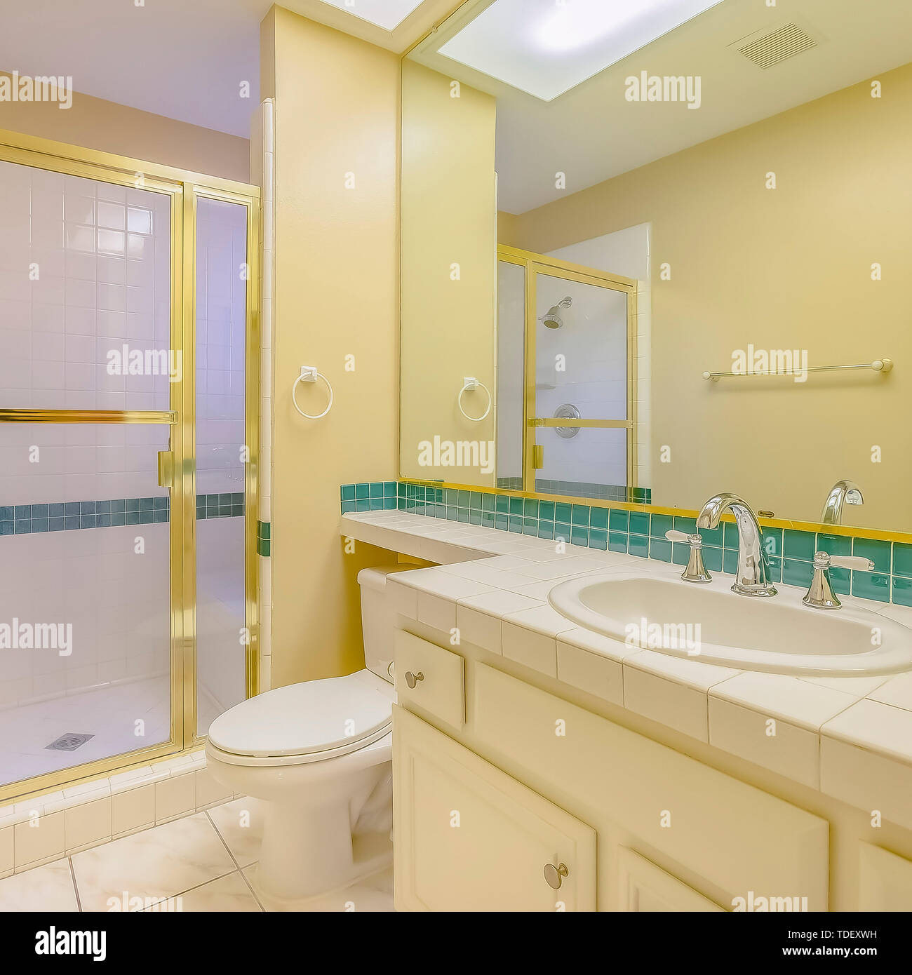 Square Bathroom interior of a house with green and gold accents. The ...