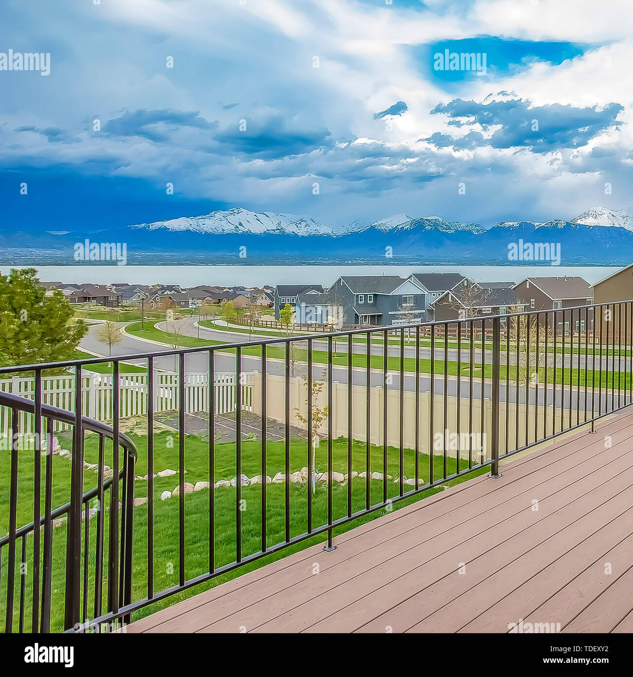 Square Balcony with wooden floor and metal railing overlooking lake and ...
