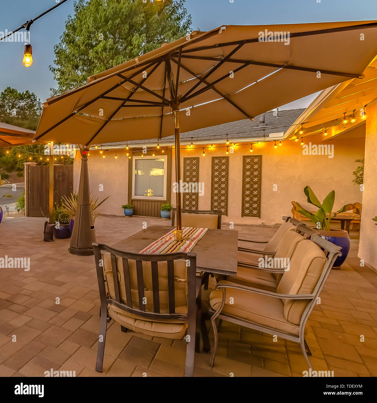 Square frame Outdoor dining and seating area on the cozy stone patio of ...