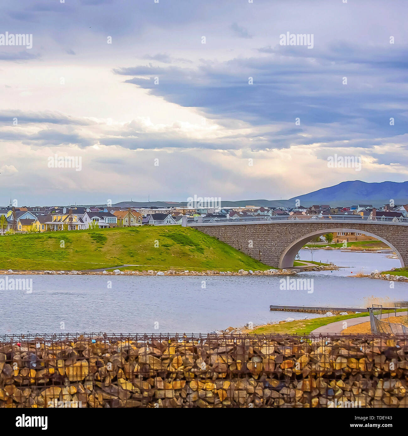 Square frame Lake with bank of stone and arched bridge under sky filled ...