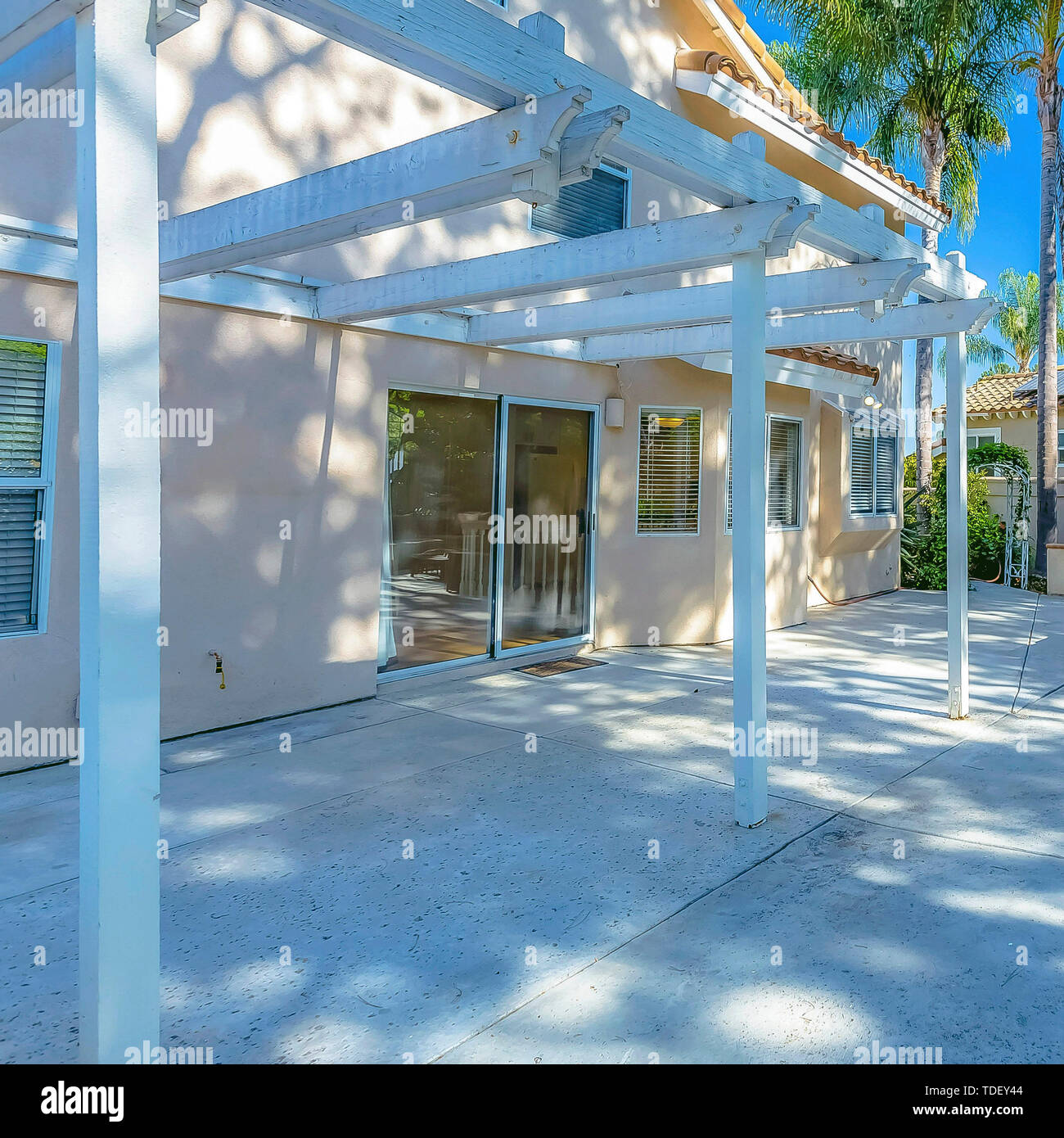 Square Seating area on the spacious patio of a house with lush plants ...