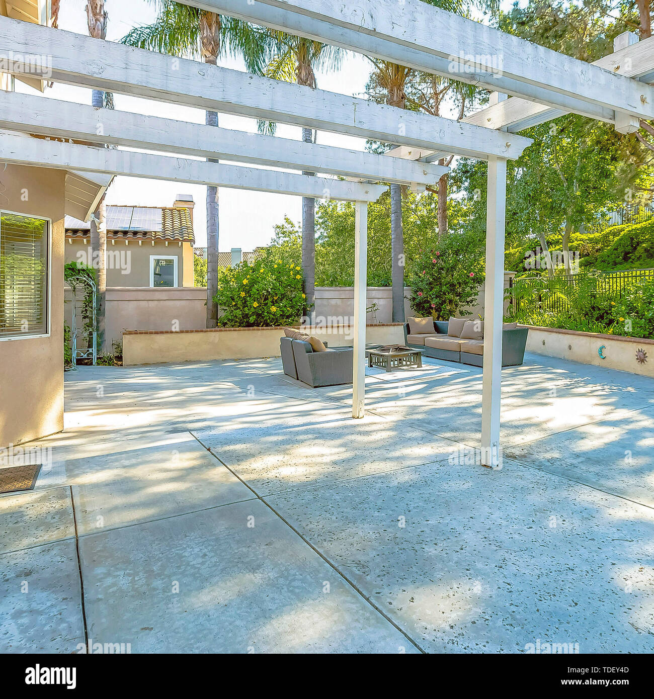 Square frame Patio with a white wooden pergola attached to the wall of ...