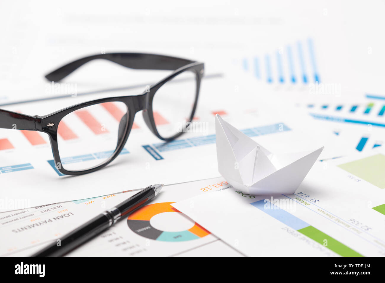 Boats made of paper graph on notebook with glasses and pen.Business ...
