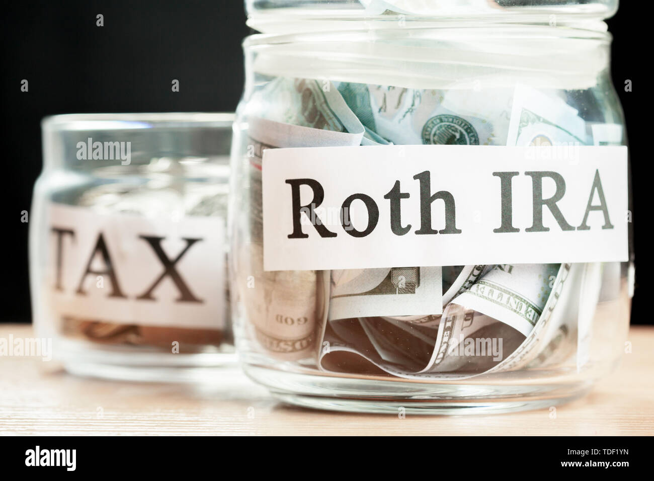glass jar used for saving US dollar bills and notes for IRA retirement ...