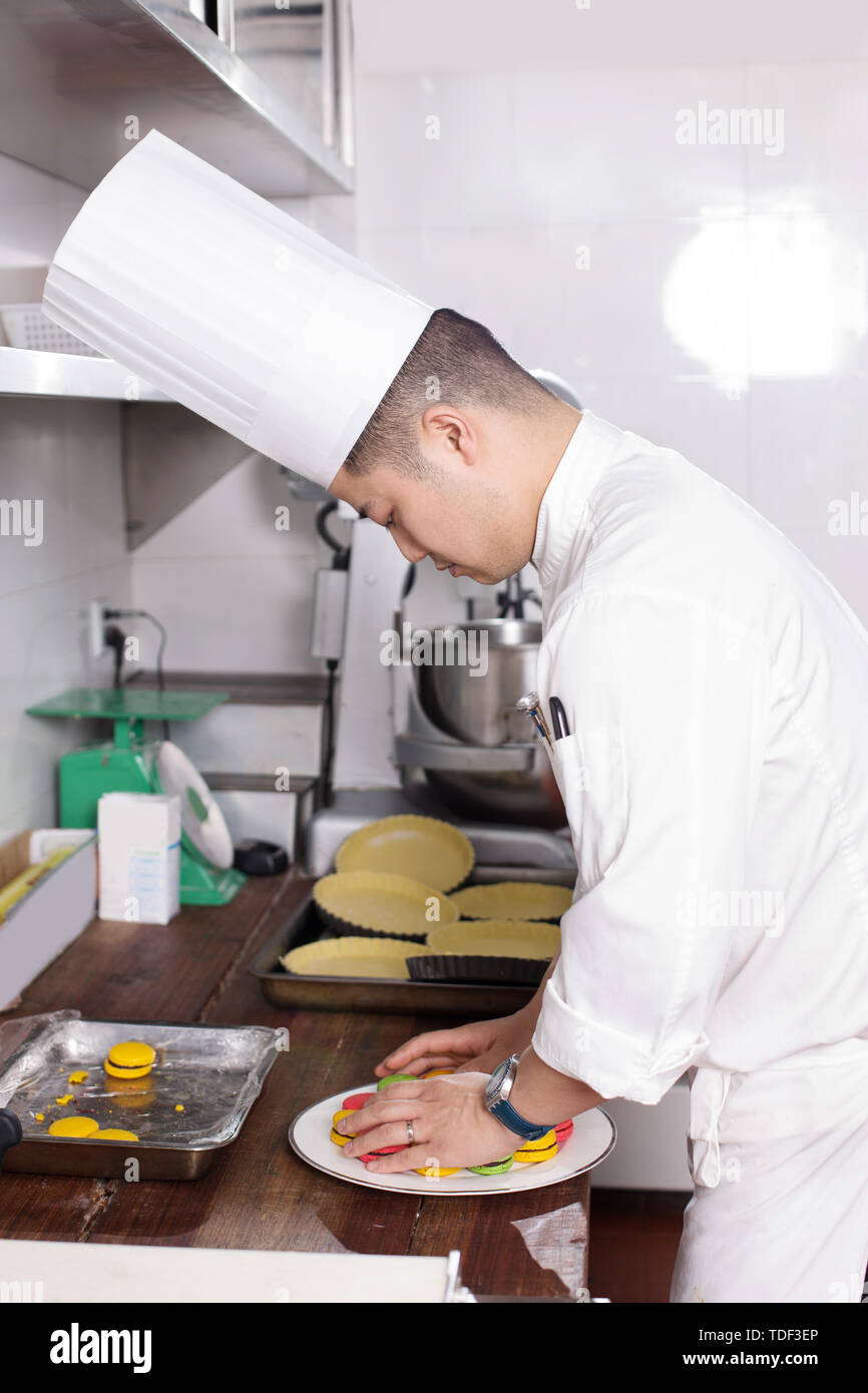 young chinese man chelf making food in modern kitchen Stock Photo - Alamy