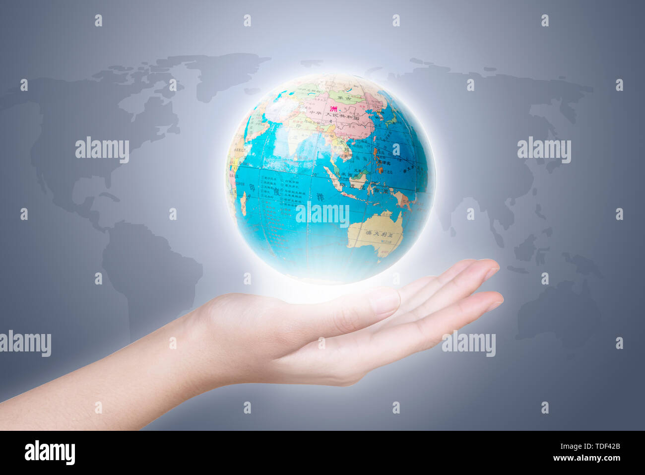 Holding a globe in hand Stock Photo - Alamy