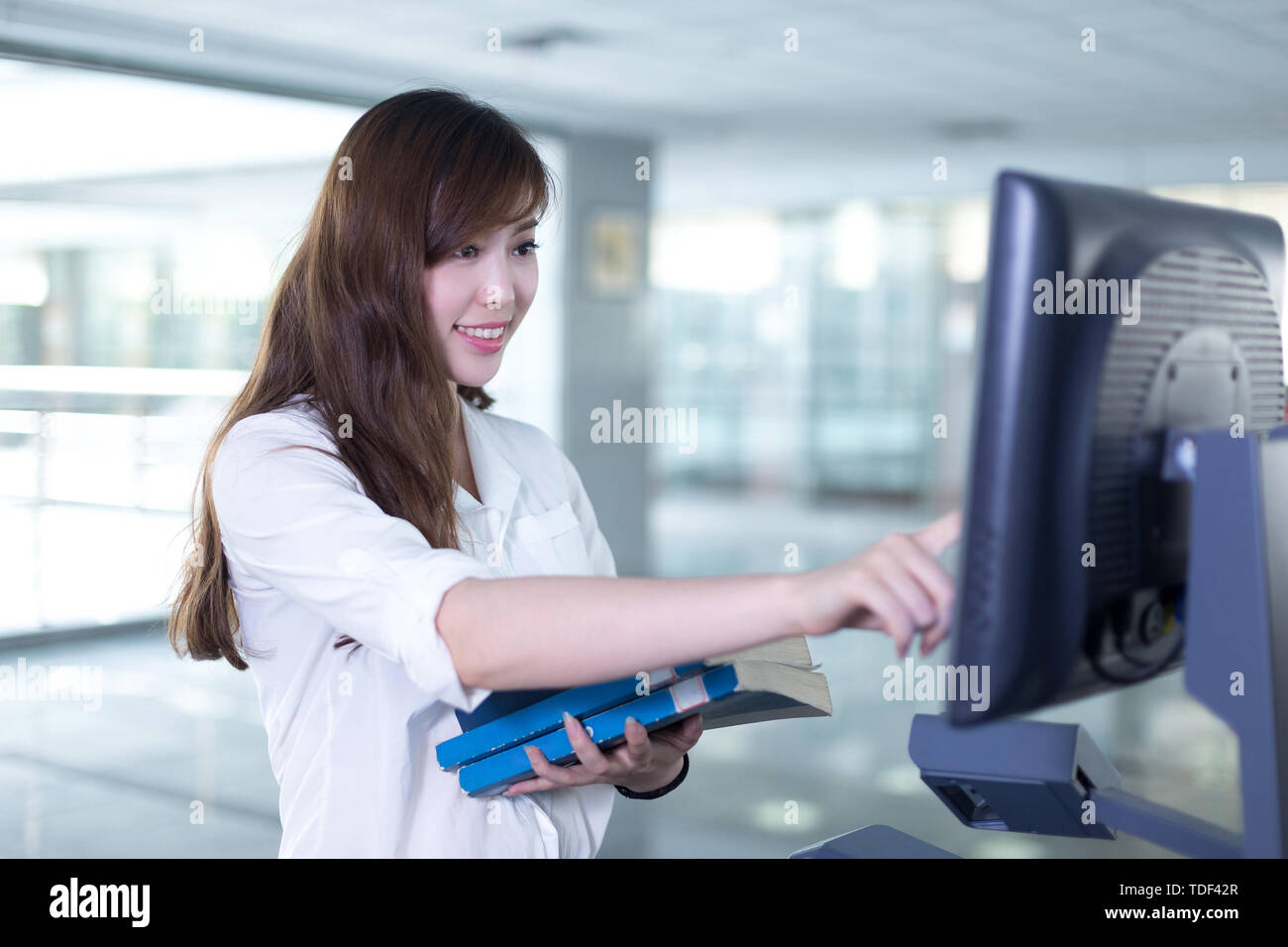 Beautiful asian student finger click screen and check book data Stock ...