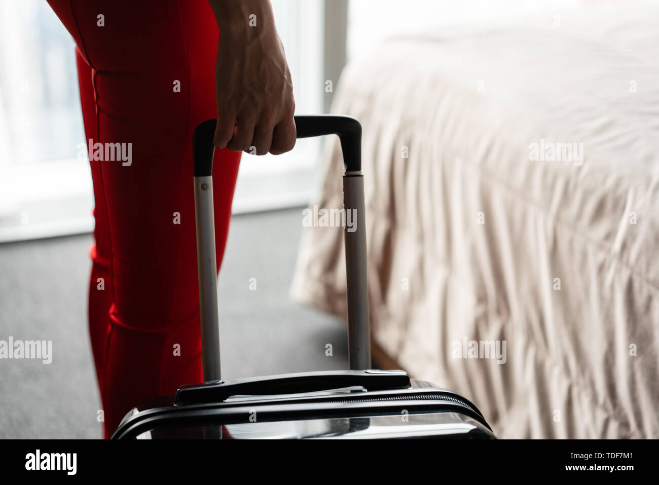 Close-up the hand holding the handle suitcase. Businesswoman arrives in ...