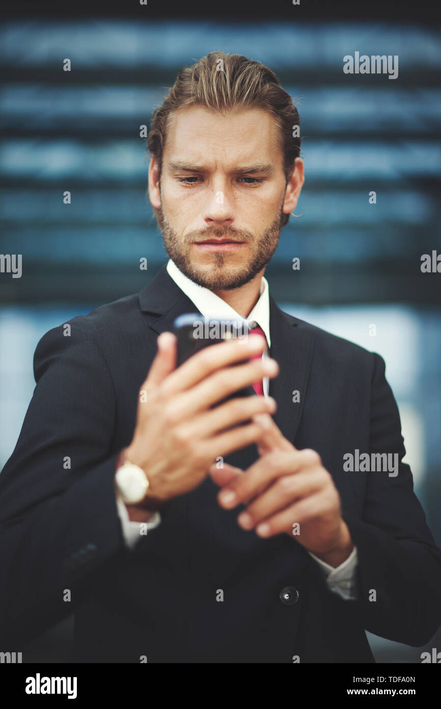 Young businessman using his phone Stock Photo - Alamy